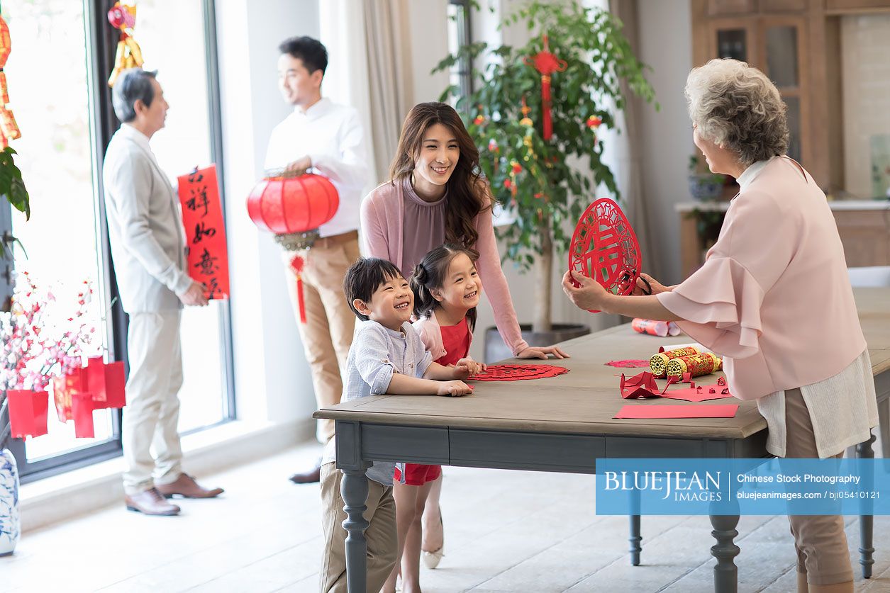 Grandchildren and grandmother with Chinese New Year paper-cut-High-res ...