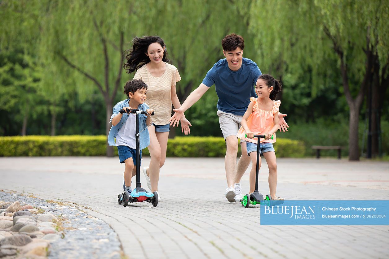 Happy young Chinese family having fun in park-High-res stock photo for download