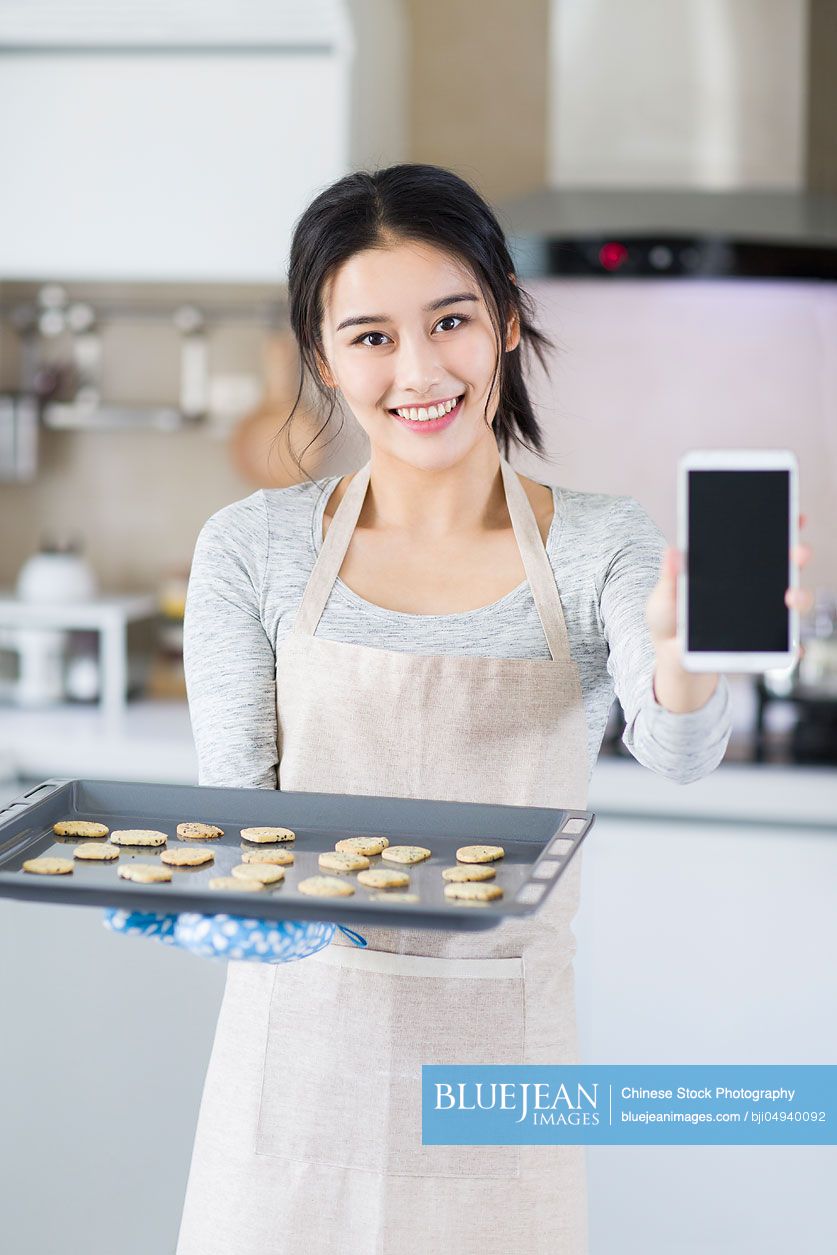 Young Chinese woman baking cookies in kitchen-High-res stock photo for ...