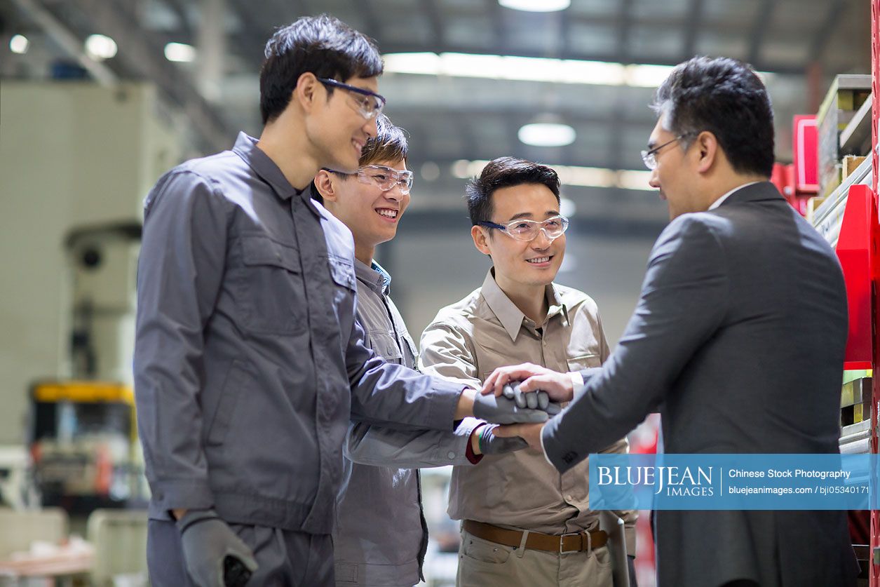 Confident Chinese businessman and engineering team in the factory-High ...
