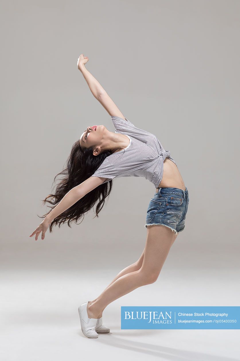 Happy young Chinese woman dancing-High-res stock photo for download