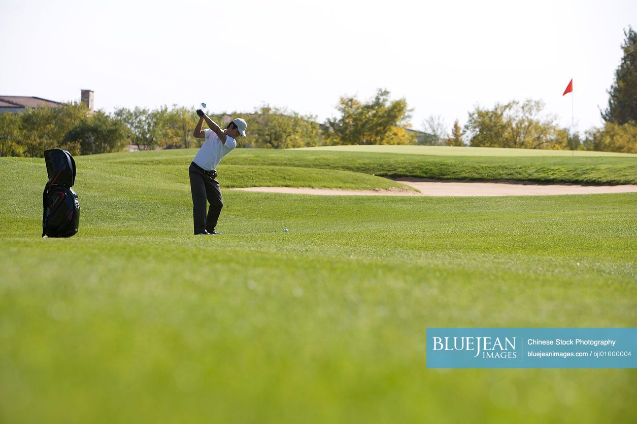 Chinese man swinging golf club on golf course-High-res stock photo for ...