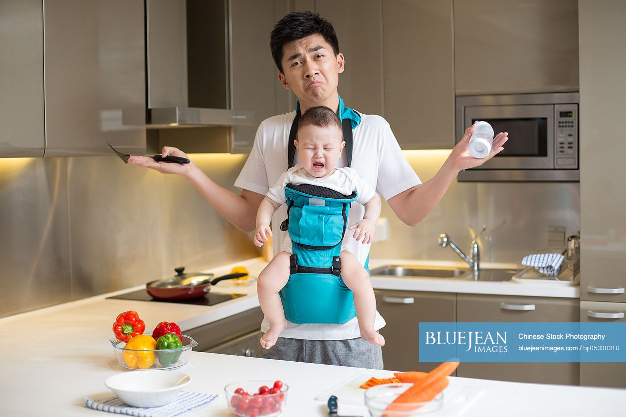 Chinese father holding baby and cooking in the kitchen-High-res stock ...