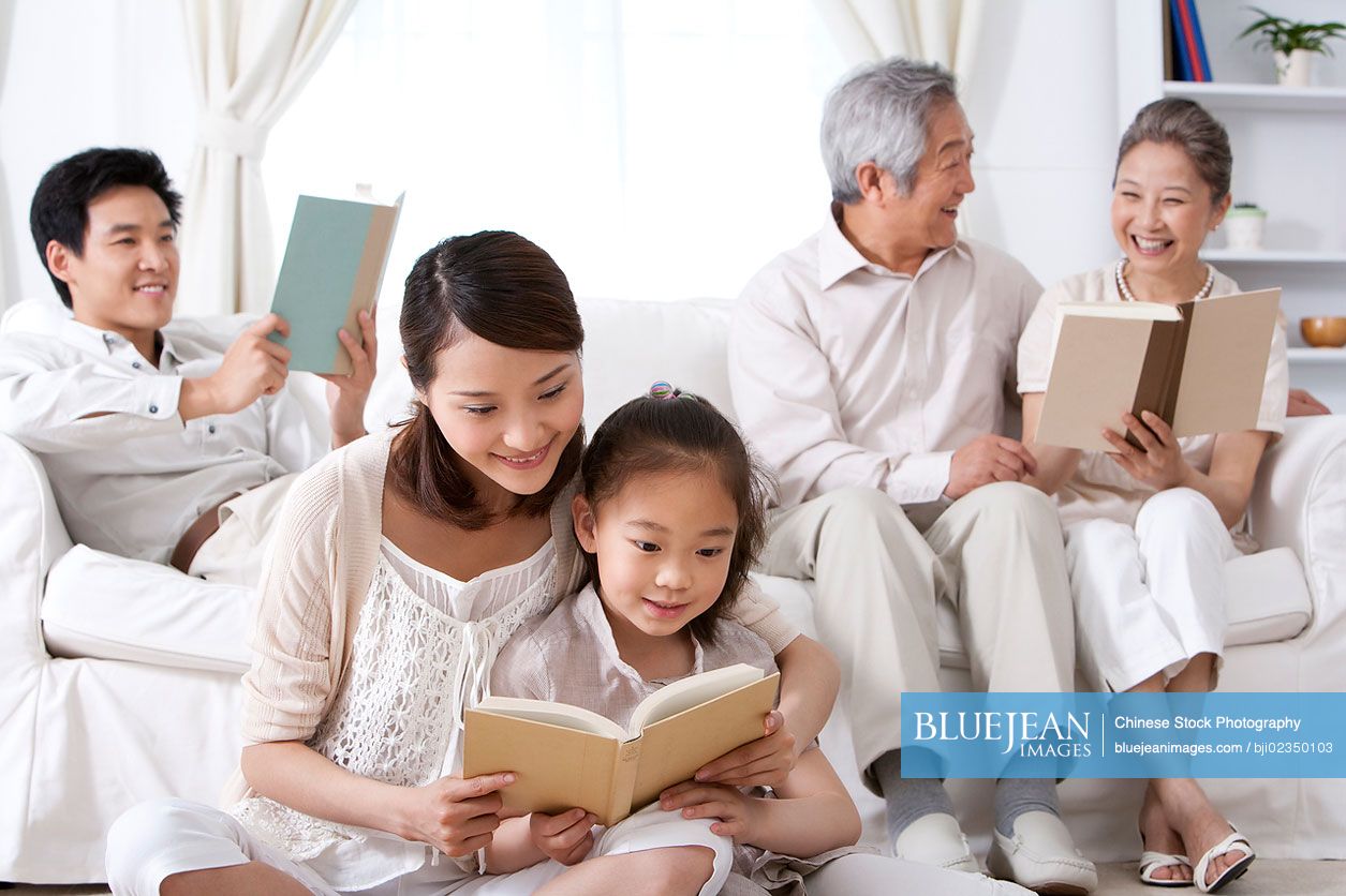 Happy Chinese family reading together-High-res stock photo for download