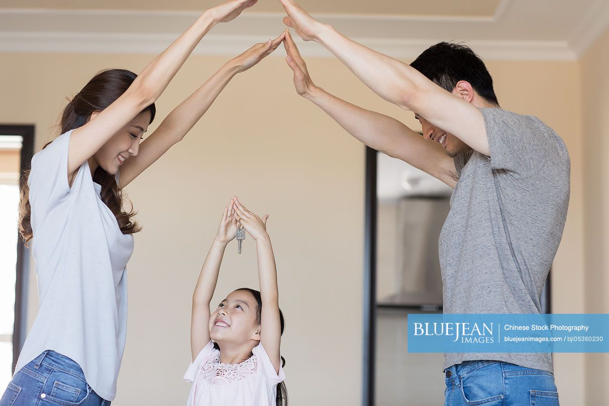 Happy young Chinese family holding keys in their new house-High-res ...