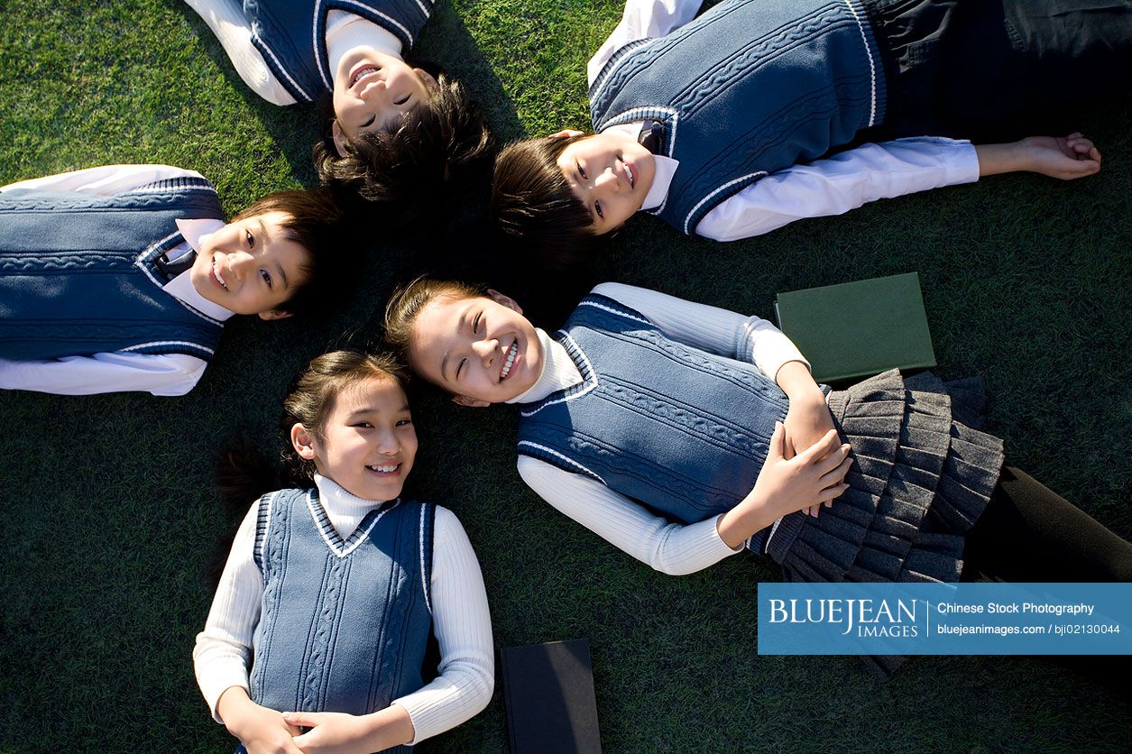 Five Chinese classmates lying on grass-High-res stock photo for download